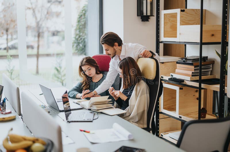 A Focused Team Collaborates on a Project in a Well-lit Modern Office ...