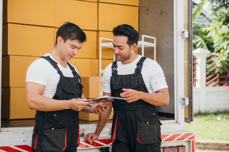 Colleague Documents while the Delivery Man Unloads Boxes. Teamwork in ...
