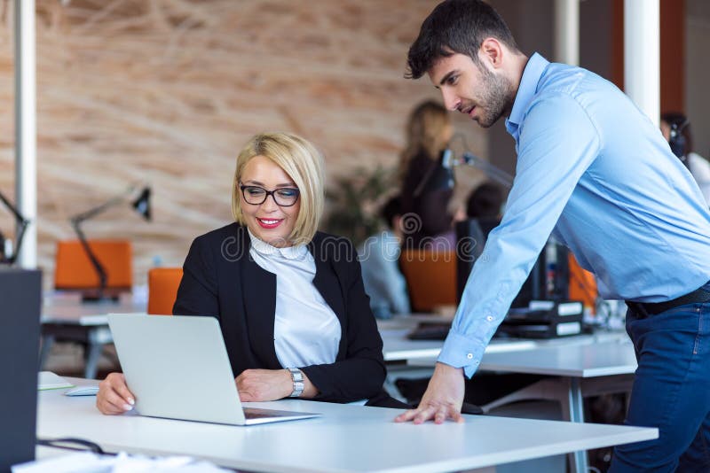 Colleagues Chatting, Sitting Together at Office Table, Smiling Stock ...