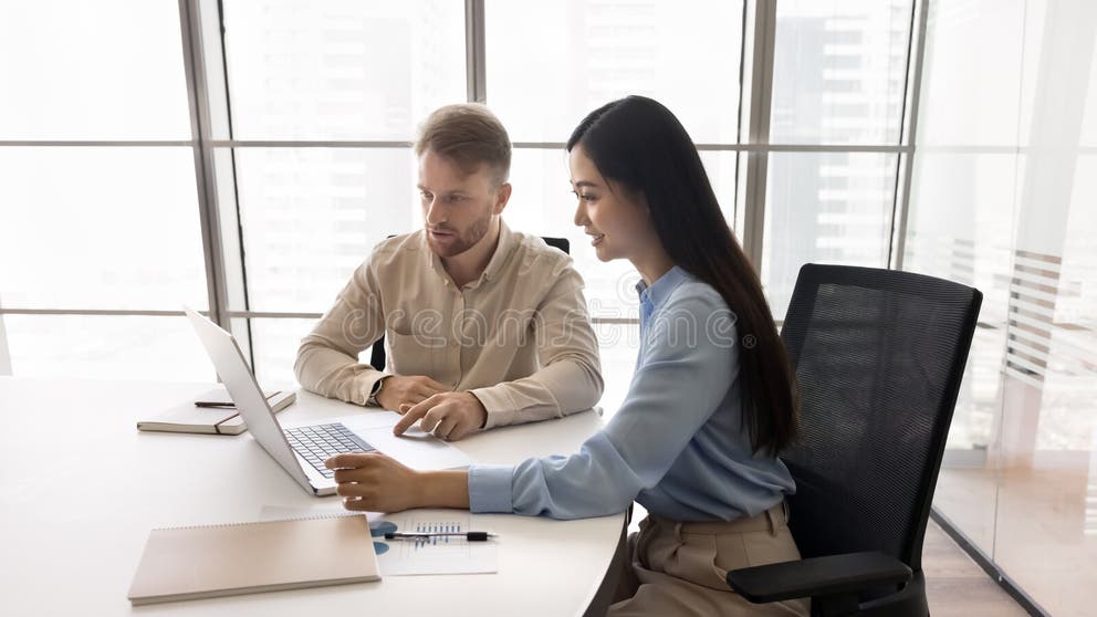 Colleagues Collaborate Using Laptop in Modern Office Stock Photo ...