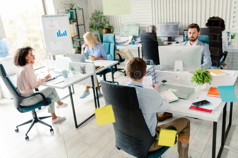 Colleagues Collaborating in a Modern Office Workspace with Daylight and ...