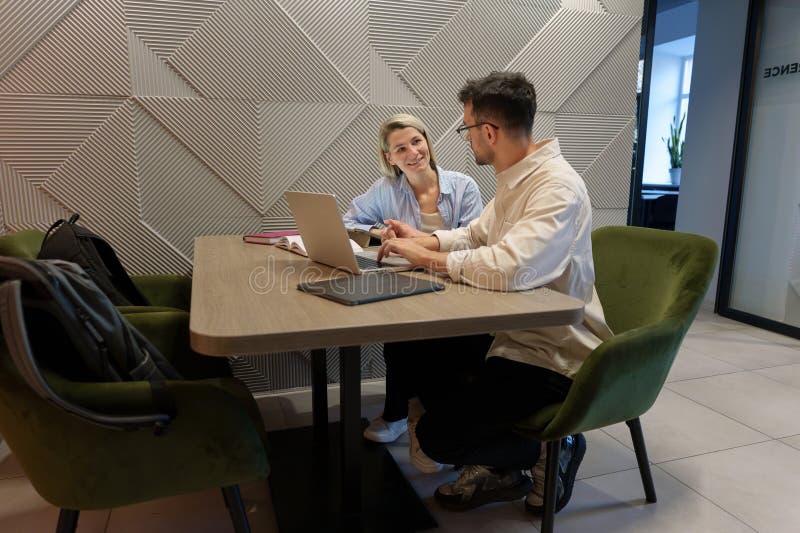 Colleagues Collaborating in a Modern Workspace with a Laptop and ...