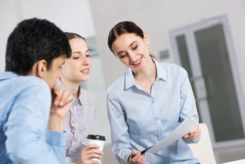 Colleagues Discuss Documents Sitting at a Small Table Stock Image ...