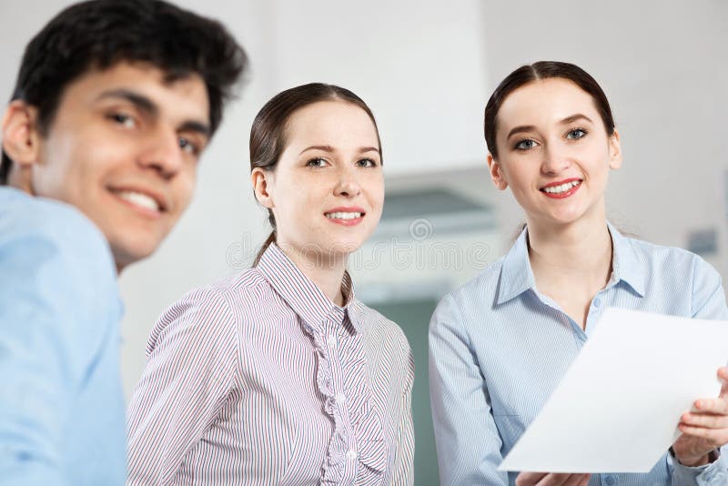 Colleagues Discuss Documents Sitting at a Small Table Stock Photo ...