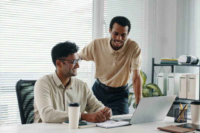 Colleagues Discussing Online Work on Laptop Stock Photo - Image of ...