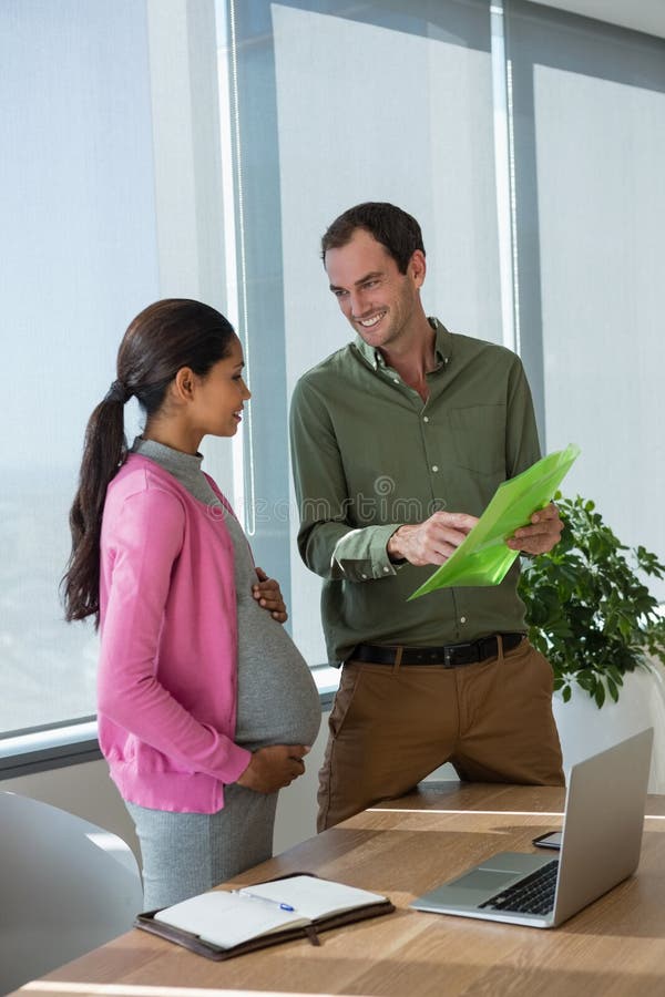 Colleagues Discussing Over File at Desk Stock Image - Image of indoors ...