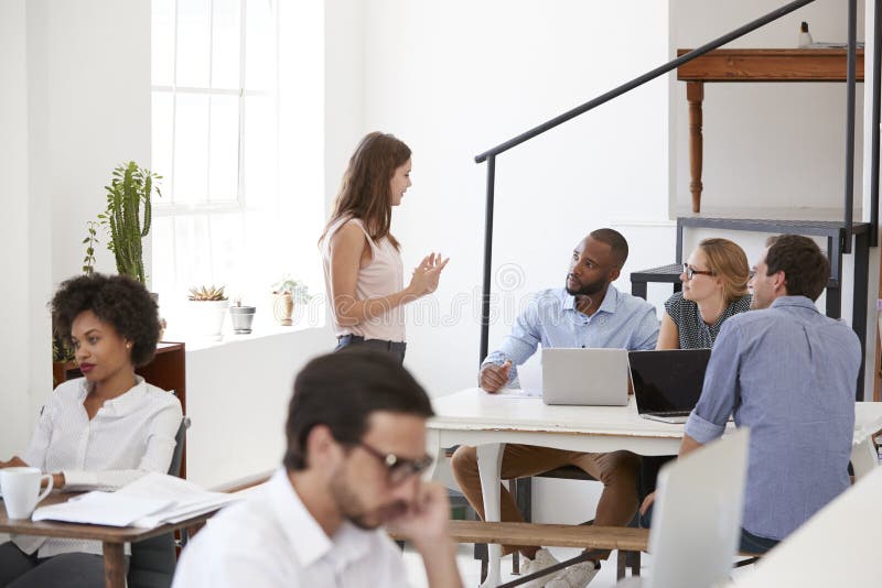Colleagues in Discussion Around a Desk in Open Plan Office Stock Photo ...