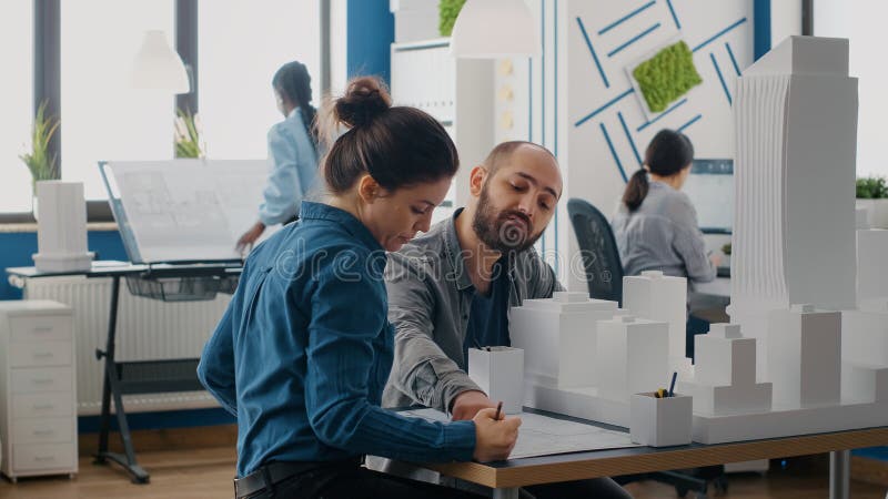 Colleagues Doing Teamwork To Design Construction Layout with Building ...