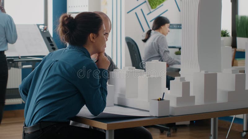 Colleagues Doing Teamwork To Design Construction Layout with Building ...