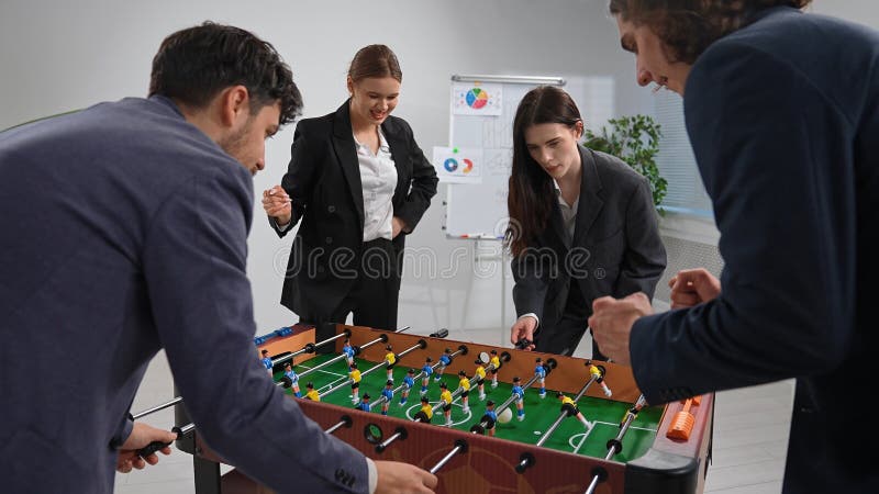 Colleagues Engaged in a Foosball Game during Office Hours Stock Photo ...