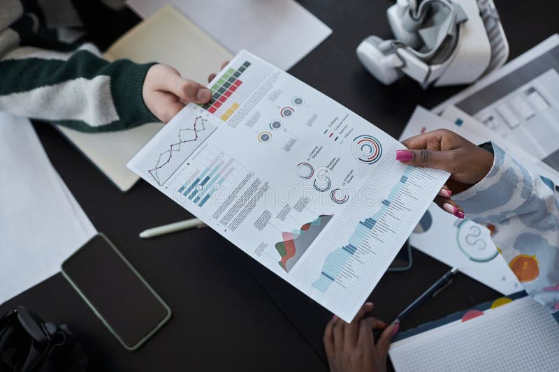 Colleagues Examining Document with Graphs Stock Photo - Image of office ...