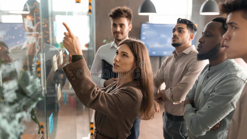 Colleagues Having Meeting Using Sticky Post-it Notes on Glass Wall ...