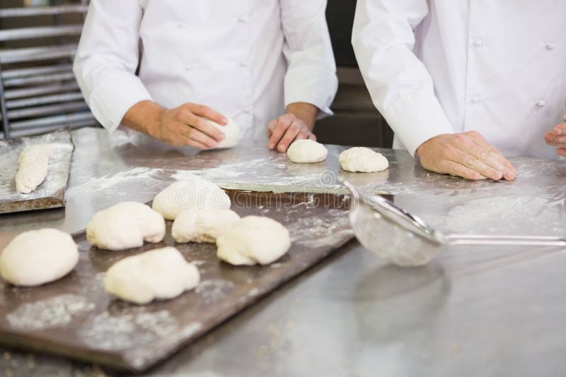 Colleagues Kneading Uncooked Dough on Worktop Stock Photo - Image of ...