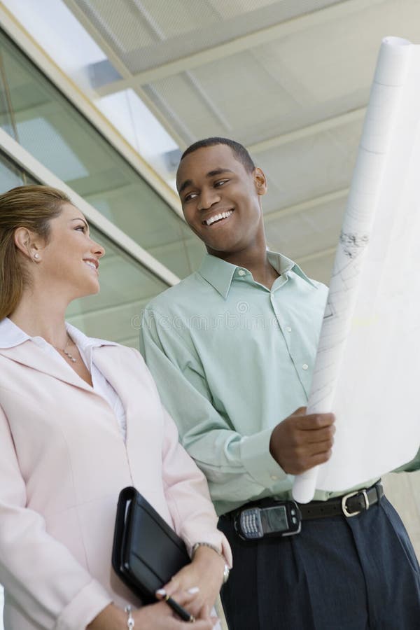 Colleagues Looking at Blueprint Stock Photo - Image of black ...