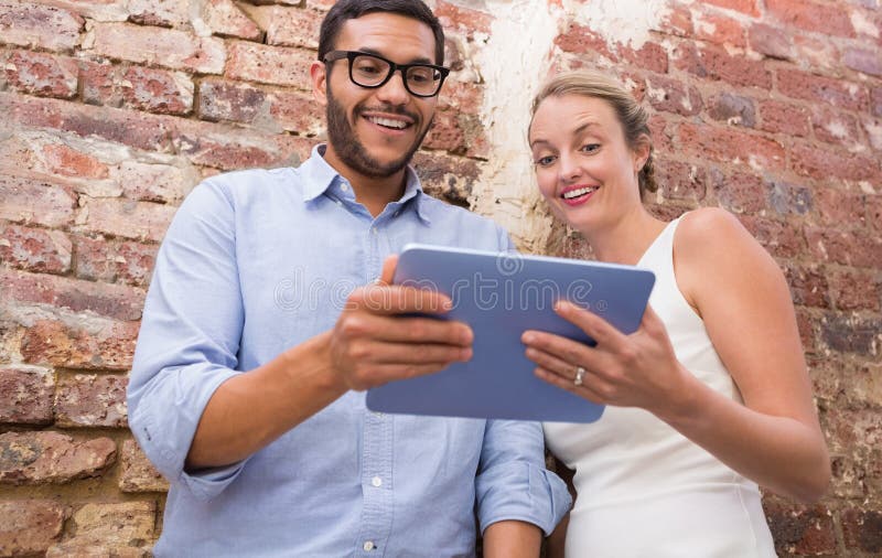 Colleagues Using Digital Tablet Against Brick Wall Stock Image - Image ...