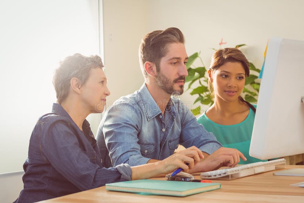 Colleagues Using Laptop at Office Stock Photo - Image of cheerful ...
