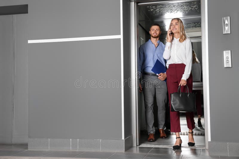 Colleagues Walking Out Modern Elevator in Office Building Stock Image ...