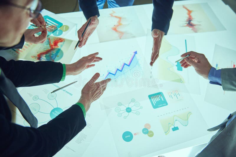 Colleagues Working with Analytical Papers, Checking Graphs and ...