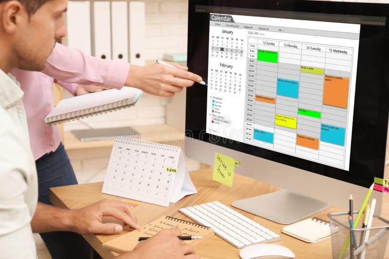 Colleagues Working with Calendar App on Computer in Office Stock Photo ...