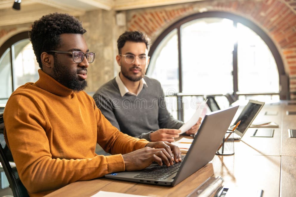 Colleagues Working on a Project and Looking Involved while Discussing ...