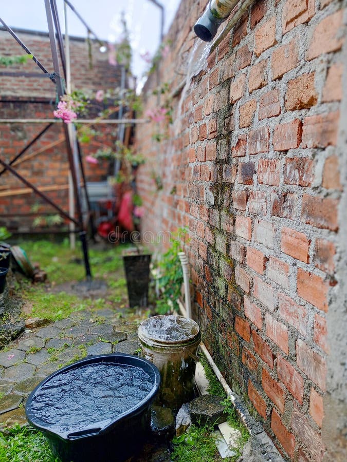 Collecting Rainwater from a Gutter into Buckets and Basins Outdoors ...