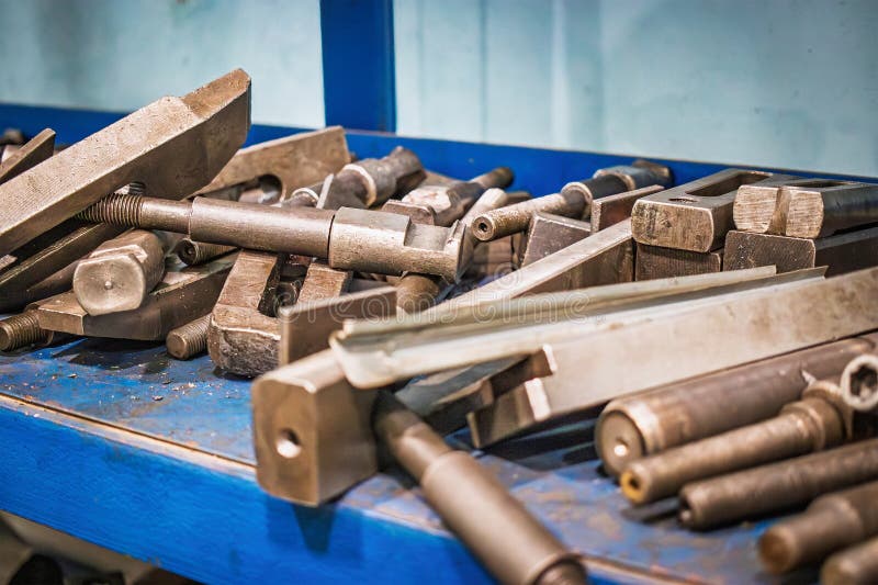 A Cluttered Workbench Filled with Various Tools for Metalworking in a ...
