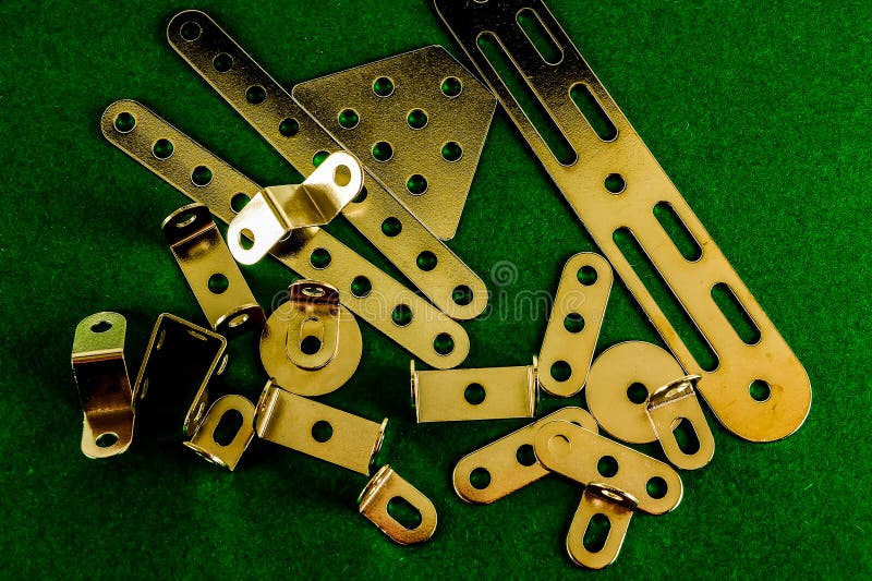 A Collection of Gold Colored Hardware Pieces are Displayed on a Green ...