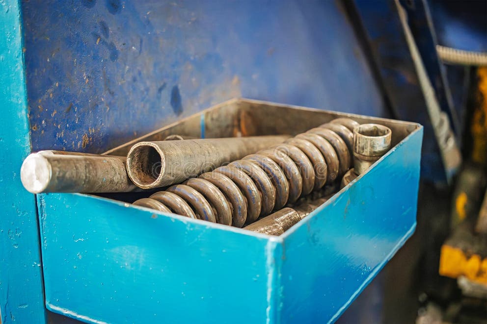 A Collection of Metal Tools and Springs Resting in a Blue Toolbox in a ...