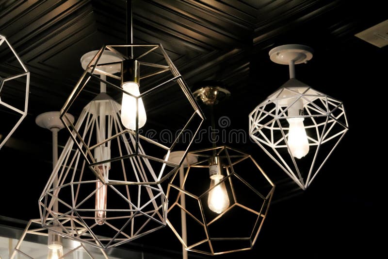 A Collection of Modern, Geometric Pendant Lights Hanging from a Dark ...