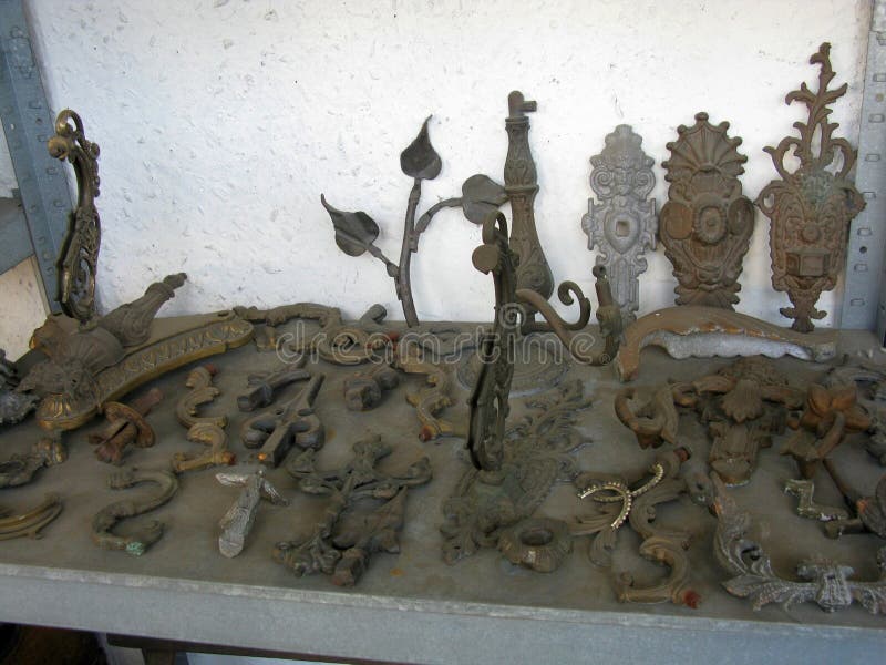 Collection of Ornate Aged Metal Decorative Pieces on Rustic Workshop ...