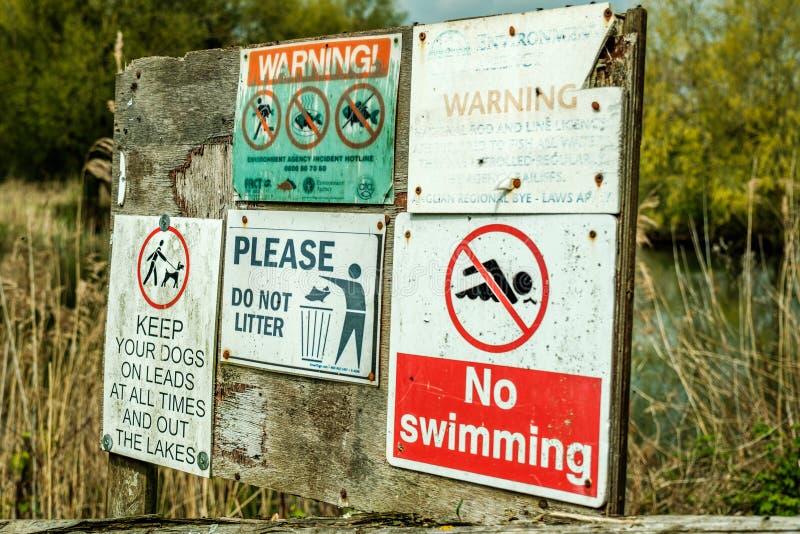 Collection of Public Safety Notices by the Side of a Lake Editorial ...