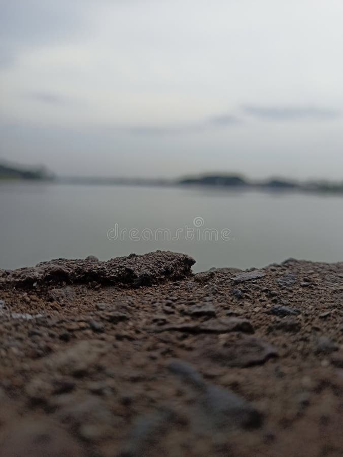 A Collection of River Rocks with a River and Clear Sky in the ...