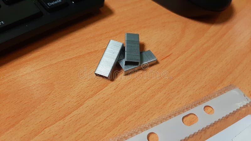 A Collection of Silver Staples on a Brown Table Stock Photo - Image of ...