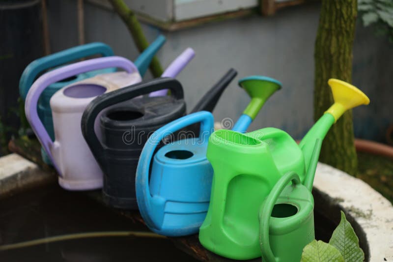 A Collection of Watering Cans Arranged on a Table Surface Stock Photo ...