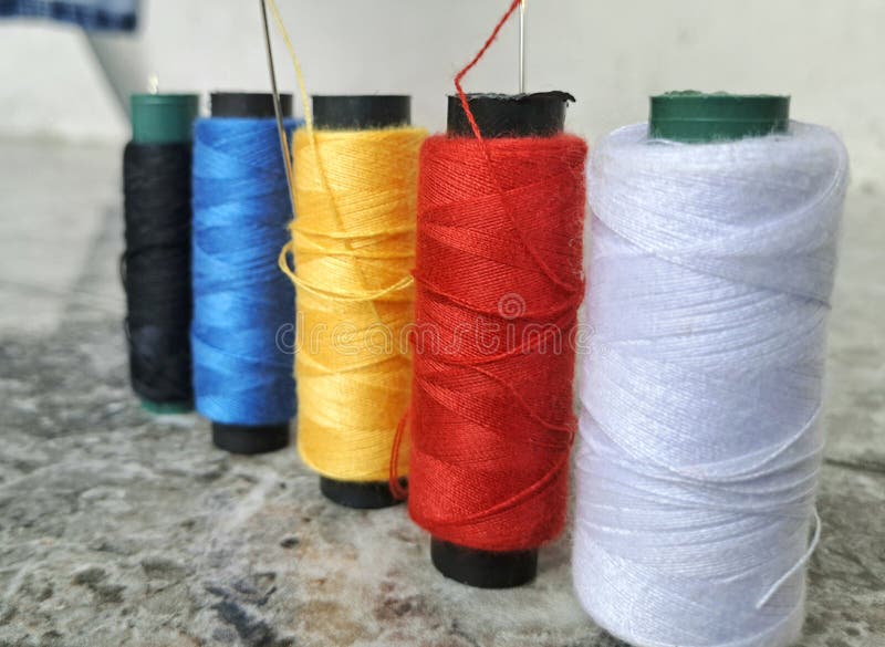 A Collection of White, Red, Yellow, Blue, and Black Sewing Threads ...