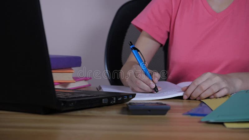 A Young Girl Wearing a Pink T-shirt Using a Laptop while Doing Research ...