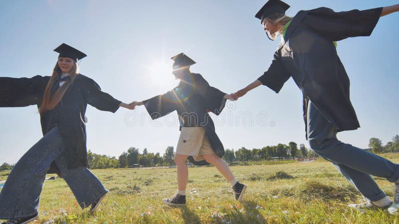 College Graduates Holding Hands Run in a Round Dance. Stock Image ...