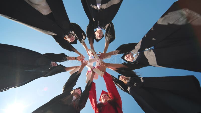 College Graduates Join Hands with Diplomas Standing in a Circle. Stock ...