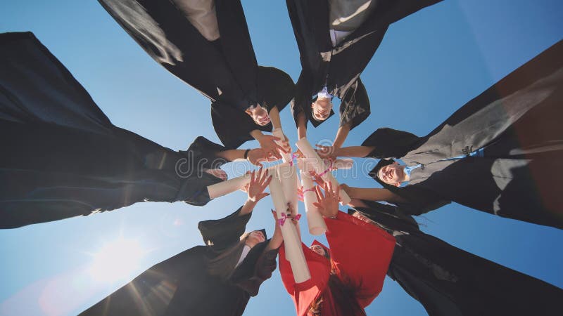 College Graduates Join Hands with Diplomas Standing in a Circle. Stock ...