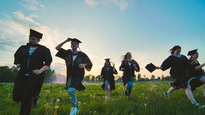 College Graduates Run at Sunset in the Evening. Stock Image - Image of ...