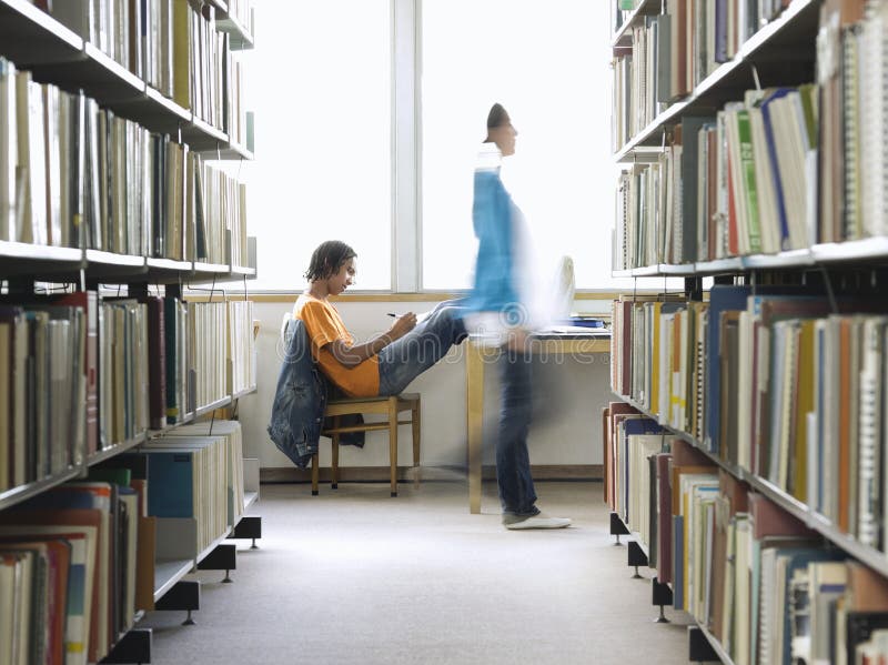 College Student Doing Homework in Library Stock Photo - Image of feet ...