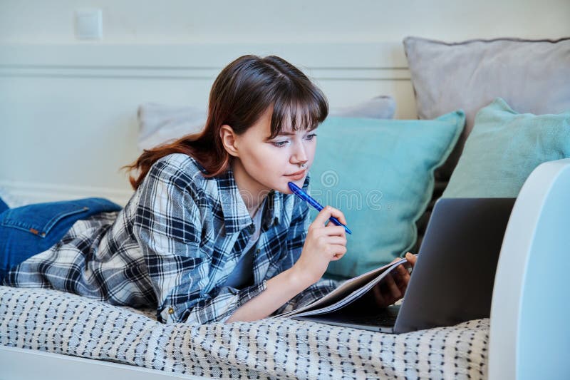 College Student Girl Studying at Home, Lying on Couch with a Laptop ...