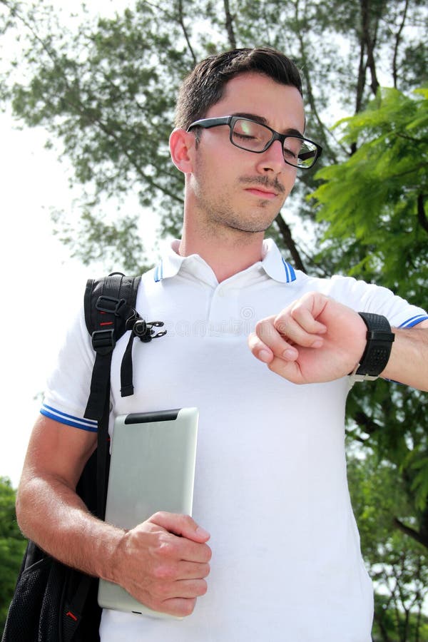 College Student Looking at the Time on His Watch Stock Photo - Image of ...