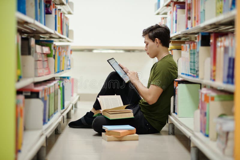 College Student Sitting on Library Floor Stock Image - Image of reading ...