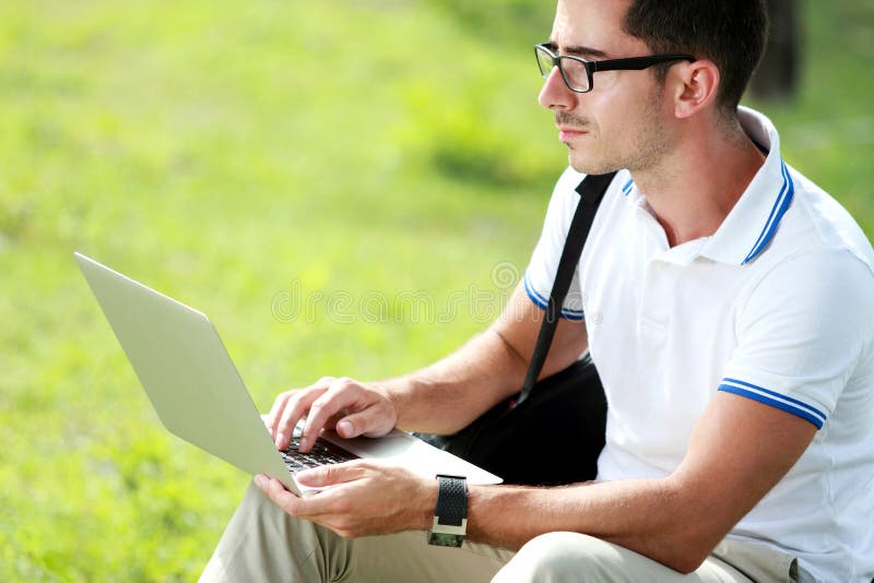 A College Student Sitting Under the Tree while Studying Using a Stock ...