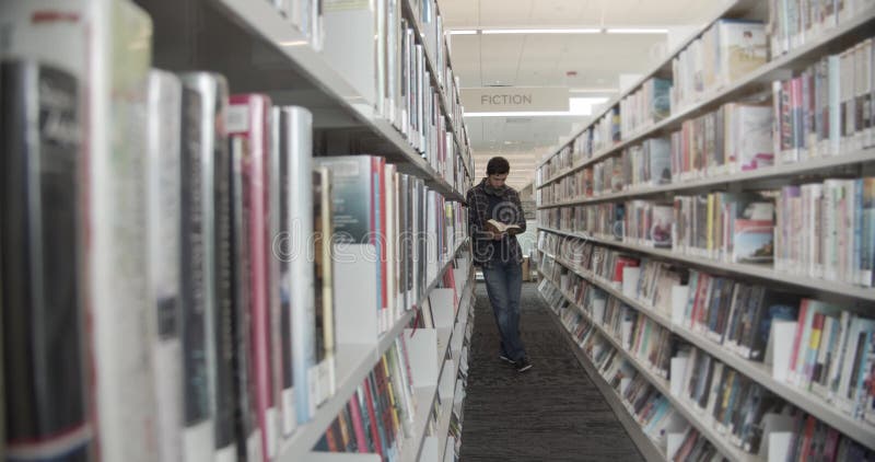 College Student Standing on Floor in Library, Reading Book. Vertical ...