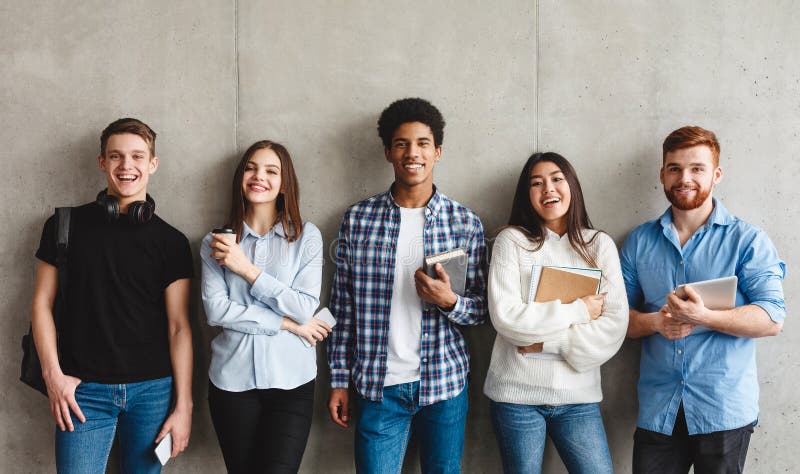 College Students with Books Smiling To Camera Over Grey Wall Stock ...