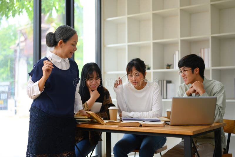 College Students Discussing with Professor during Class. Education ...