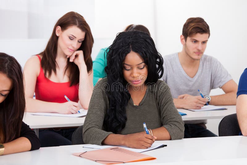 College Students Writing at Desk Stock Photo - Image of horizontal ...