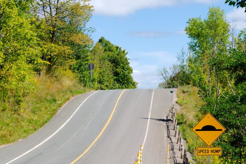 Collina Sulla Strada Con Il Segno Del Dosso Stradale Immagine Stock ...